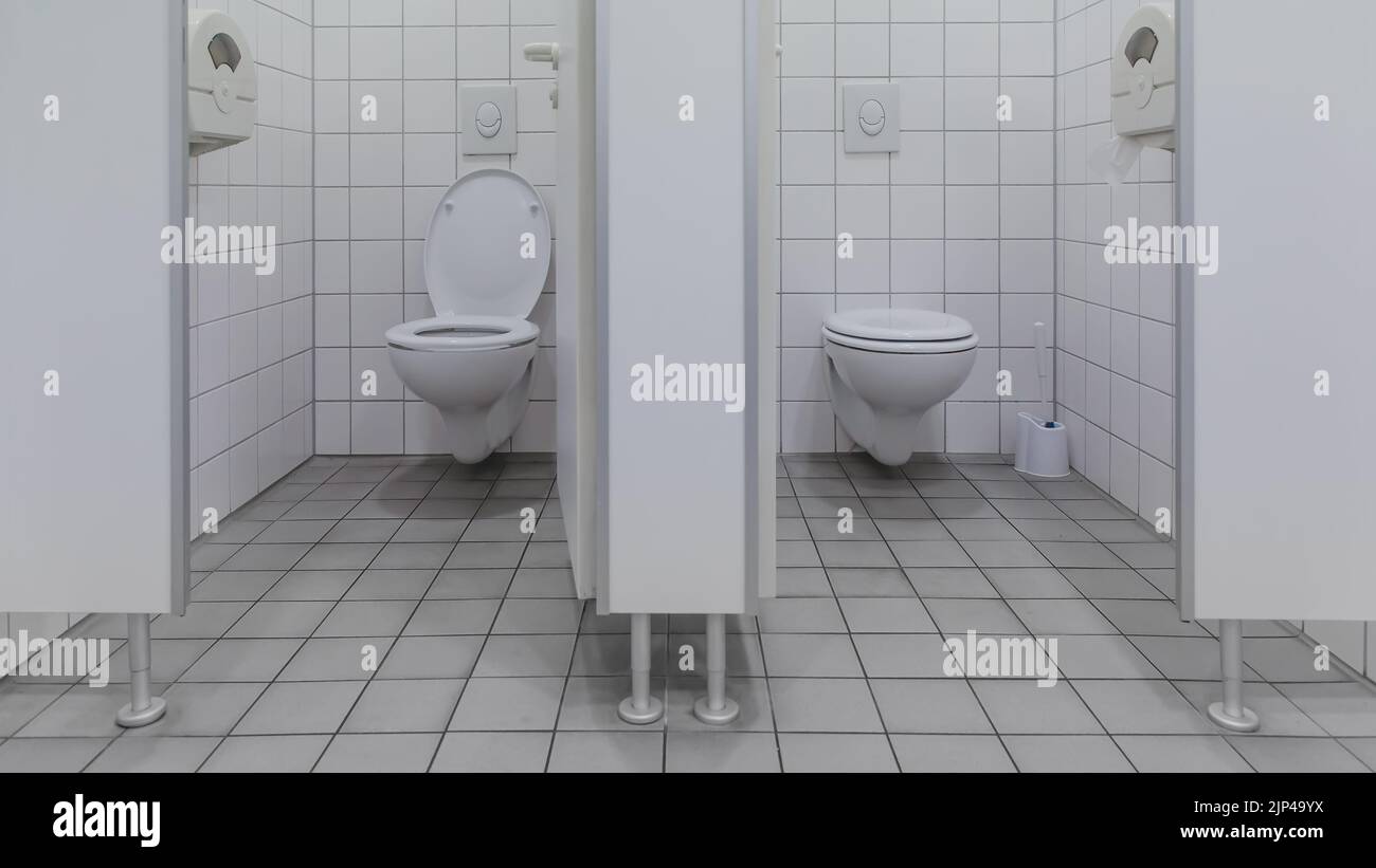 Two separated toilets at a public restroom Stock Photo - Alamy