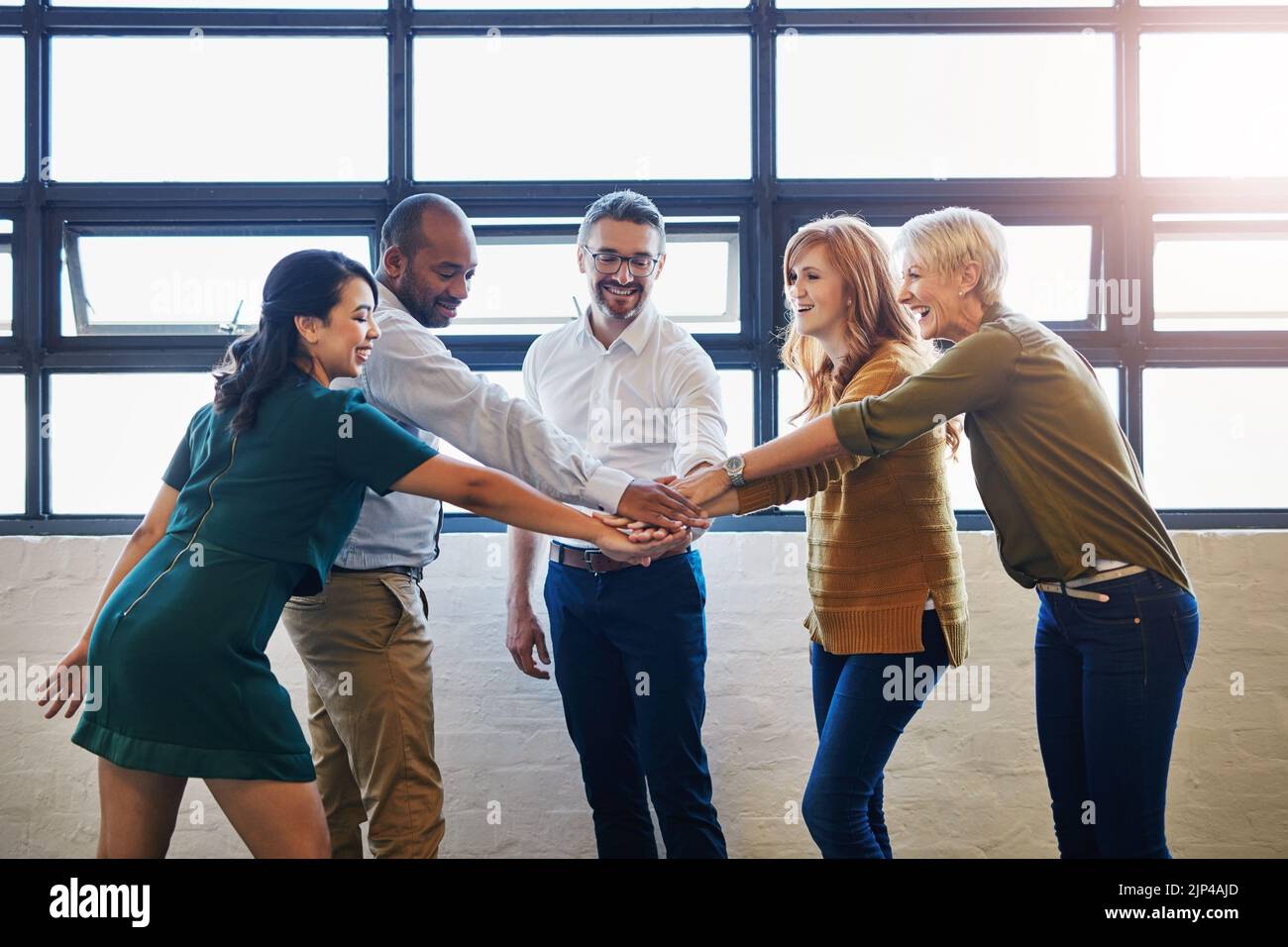 Teamwork, fun and collaboration by diverse team joining hands in team ...