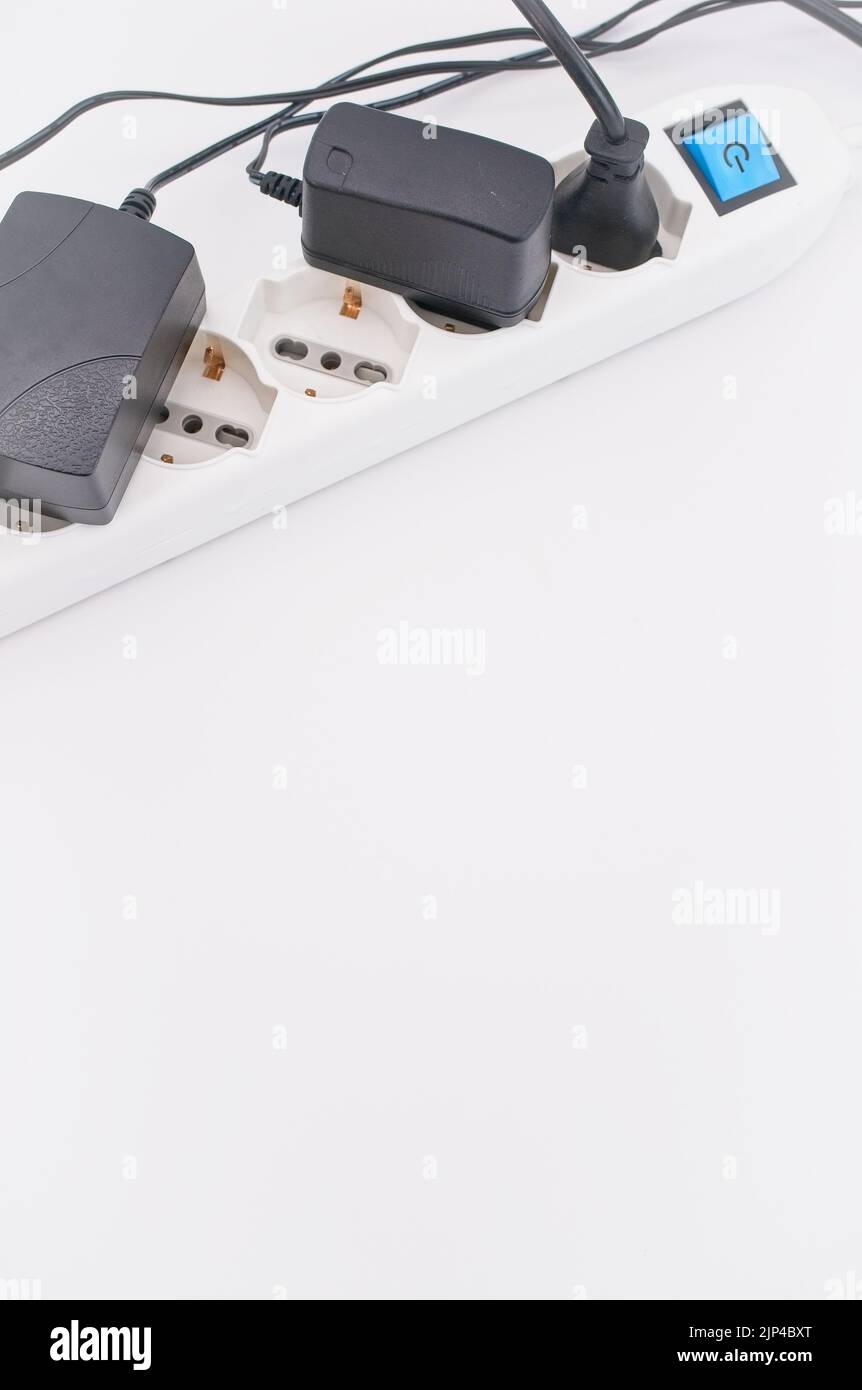 power strip and electrical cables with chargers on a white table with ...