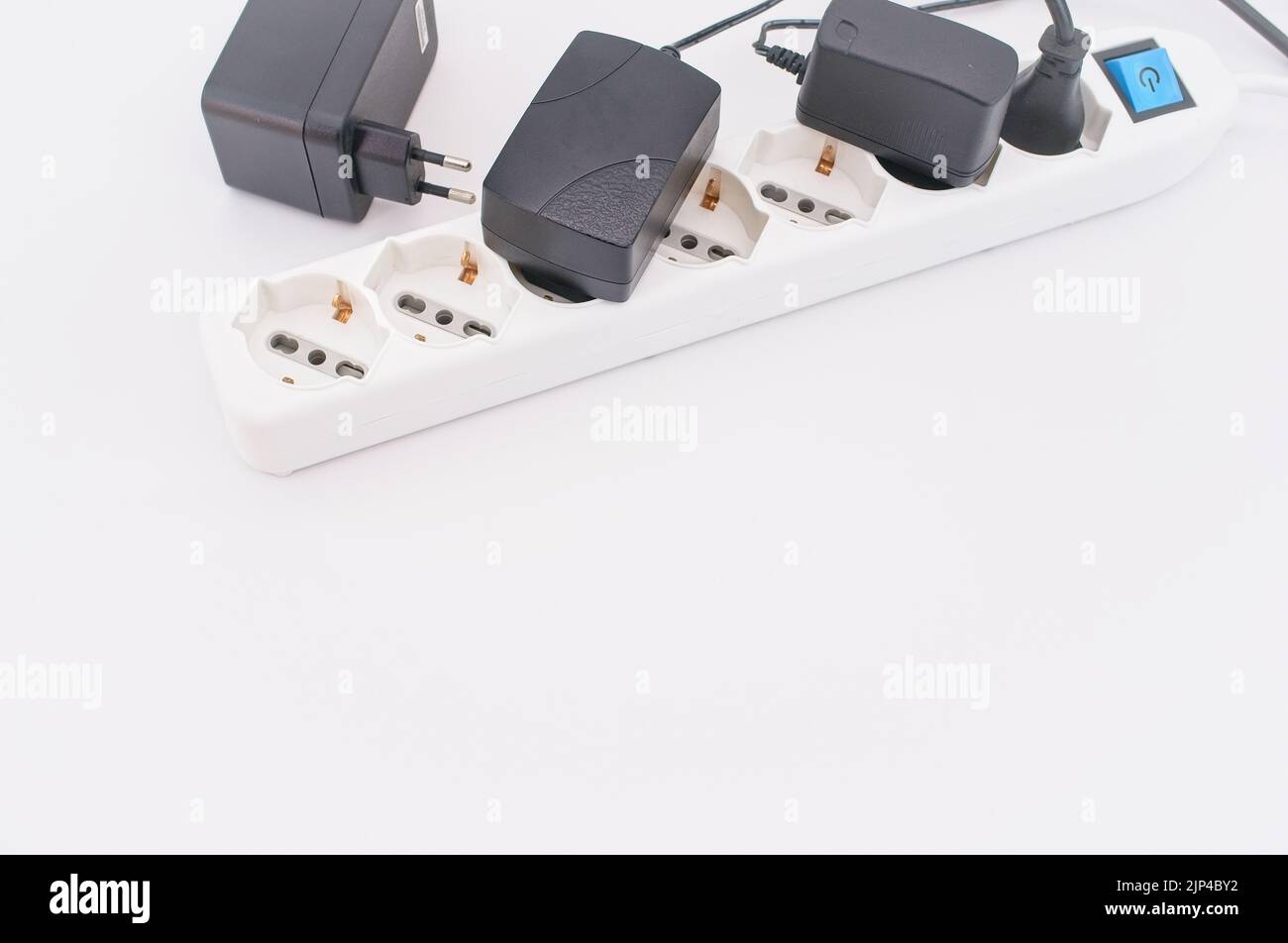 power strip and electrical cables with chargers on a white table with ...