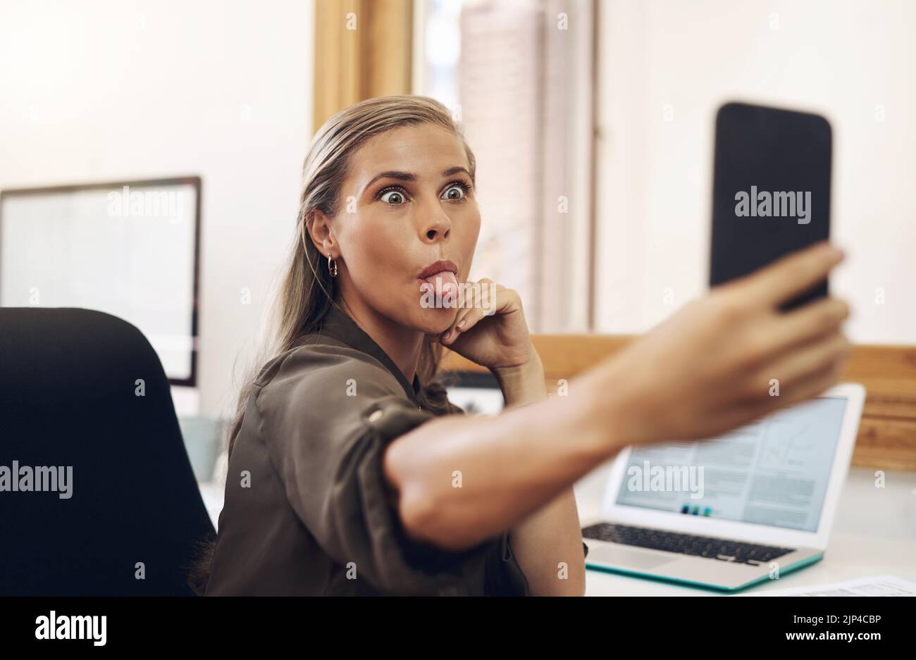Phone selfie with a playful business woman having fun, being goofy and ...