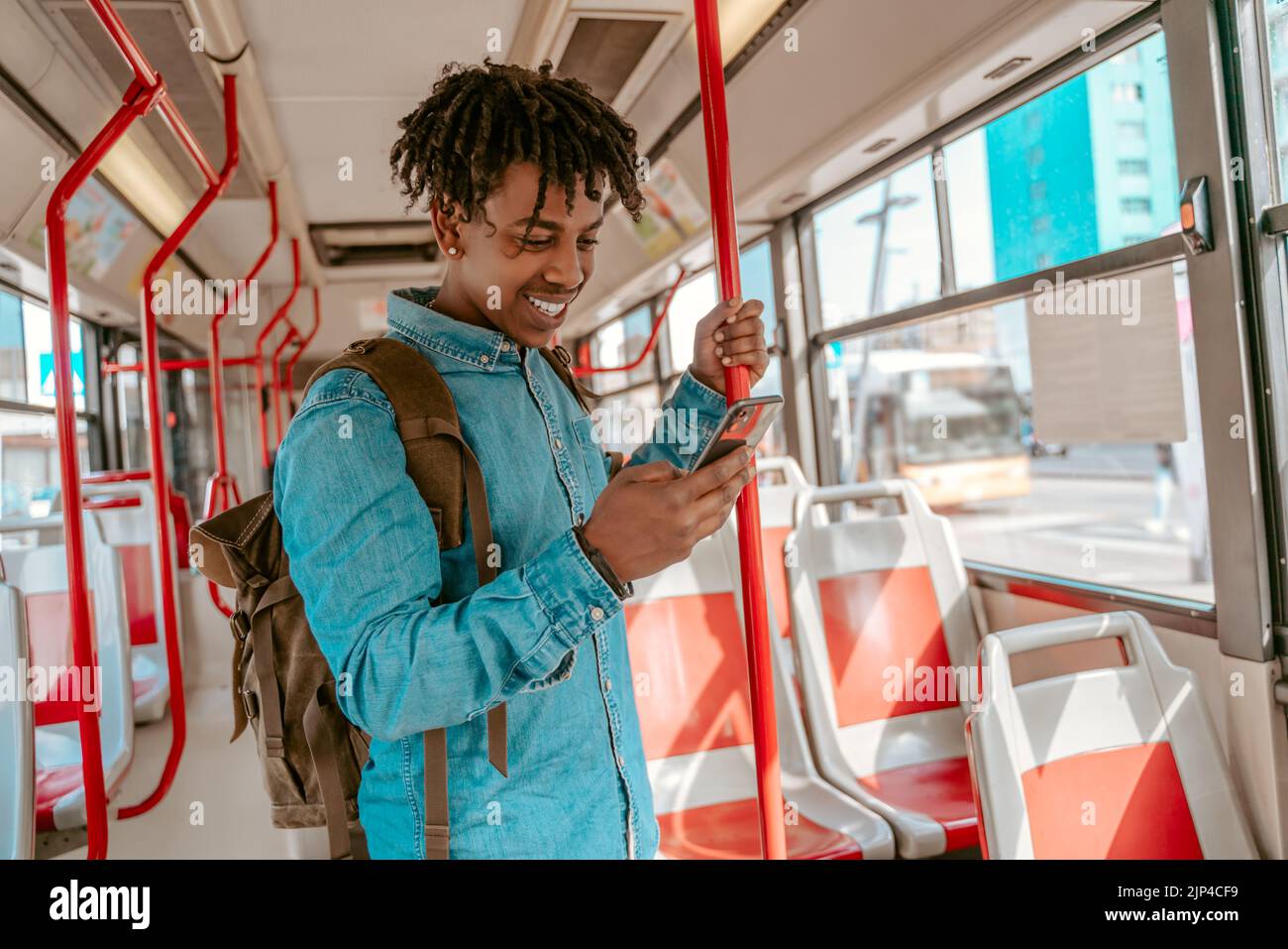Guy riding bus looking at smartphone Stock Photo - Alamy