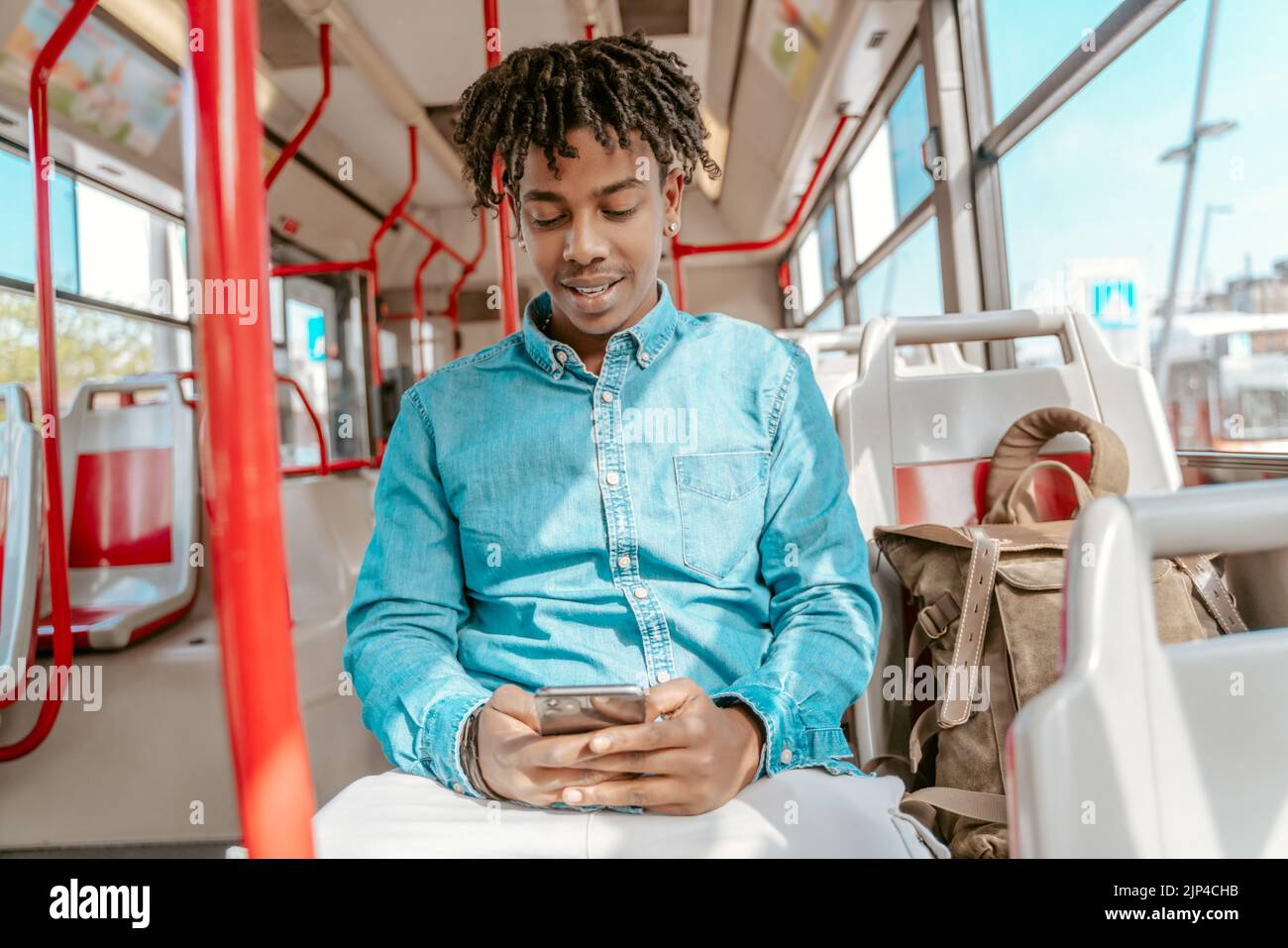 Man sitting on bus looking at screen of smartphone Stock Photo - Alamy