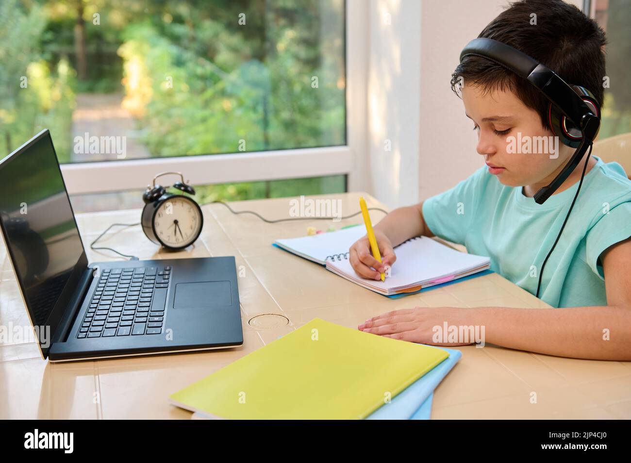 School boy having online classes, sitting at home in quarantine, using ...