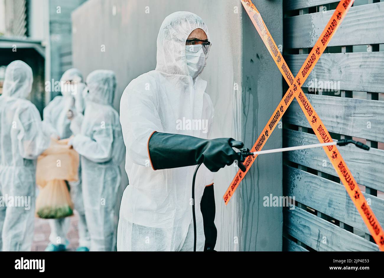 Hazmat wearing medical and healthcare worker sanitizing and cleaning a ...