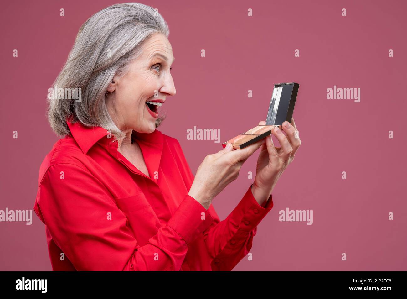 Woman holding powder box in hands and looking excited Stock Photo - Alamy