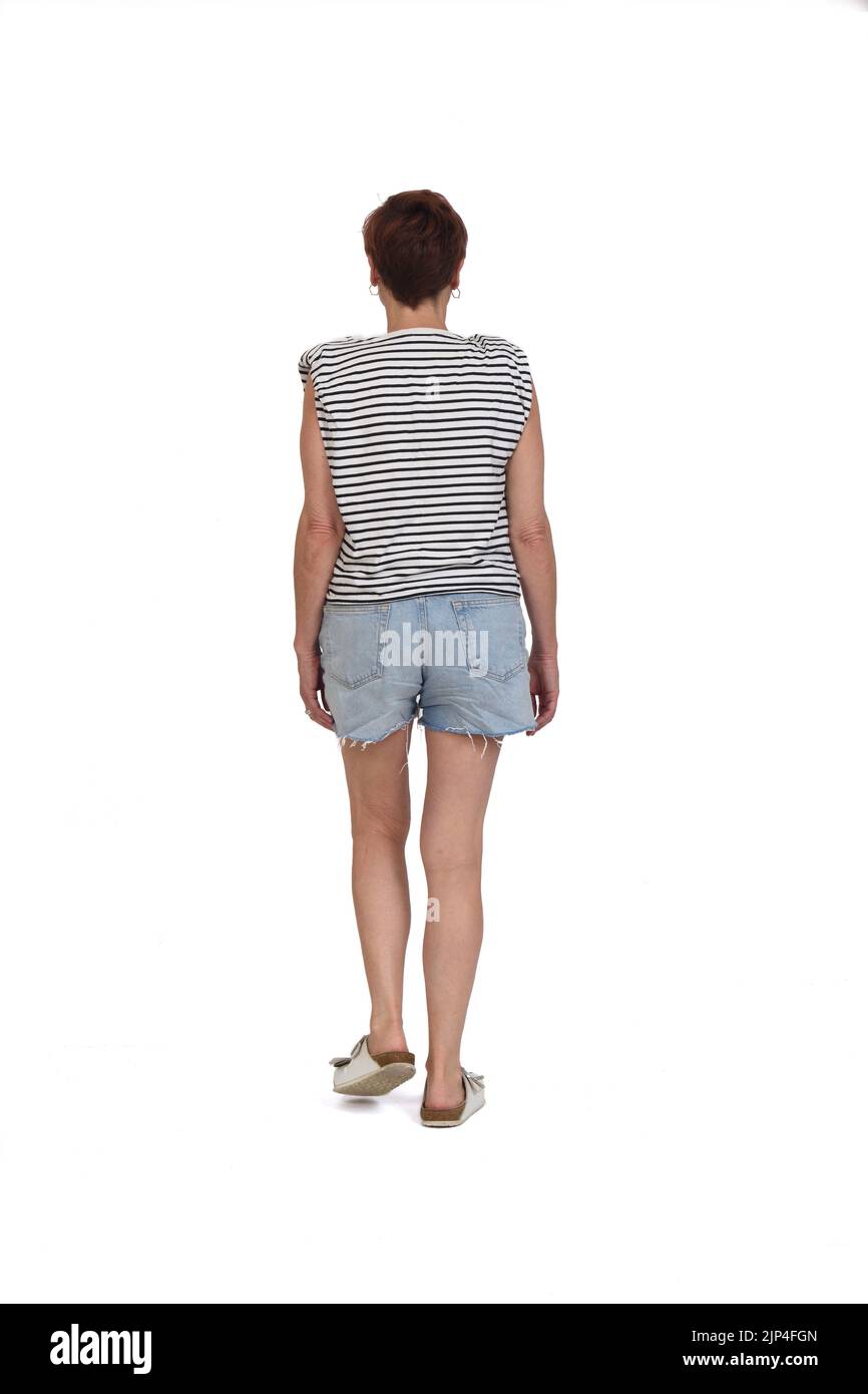 back view of a full portrait of a middle aged woman walking on white ...