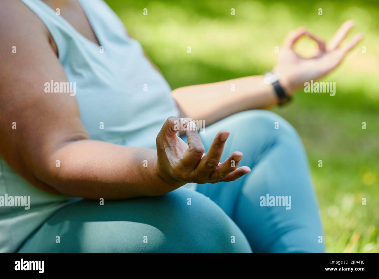 Close up of overweight black woman doing yoga outdoors and meditating ...