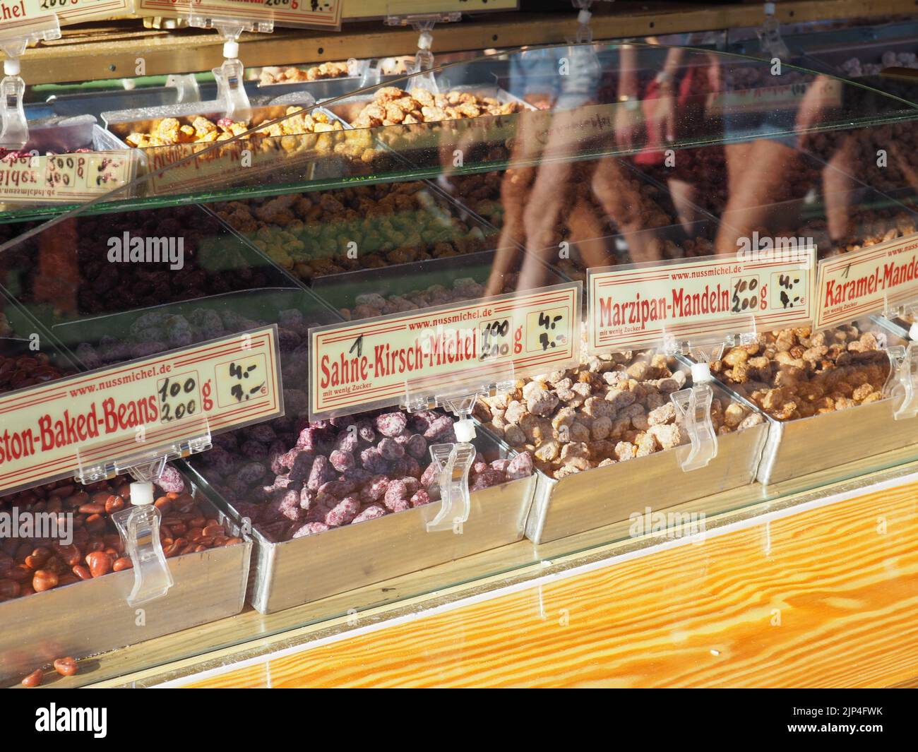 A stall display with different kinds of roasted almonds, cream cherry ...