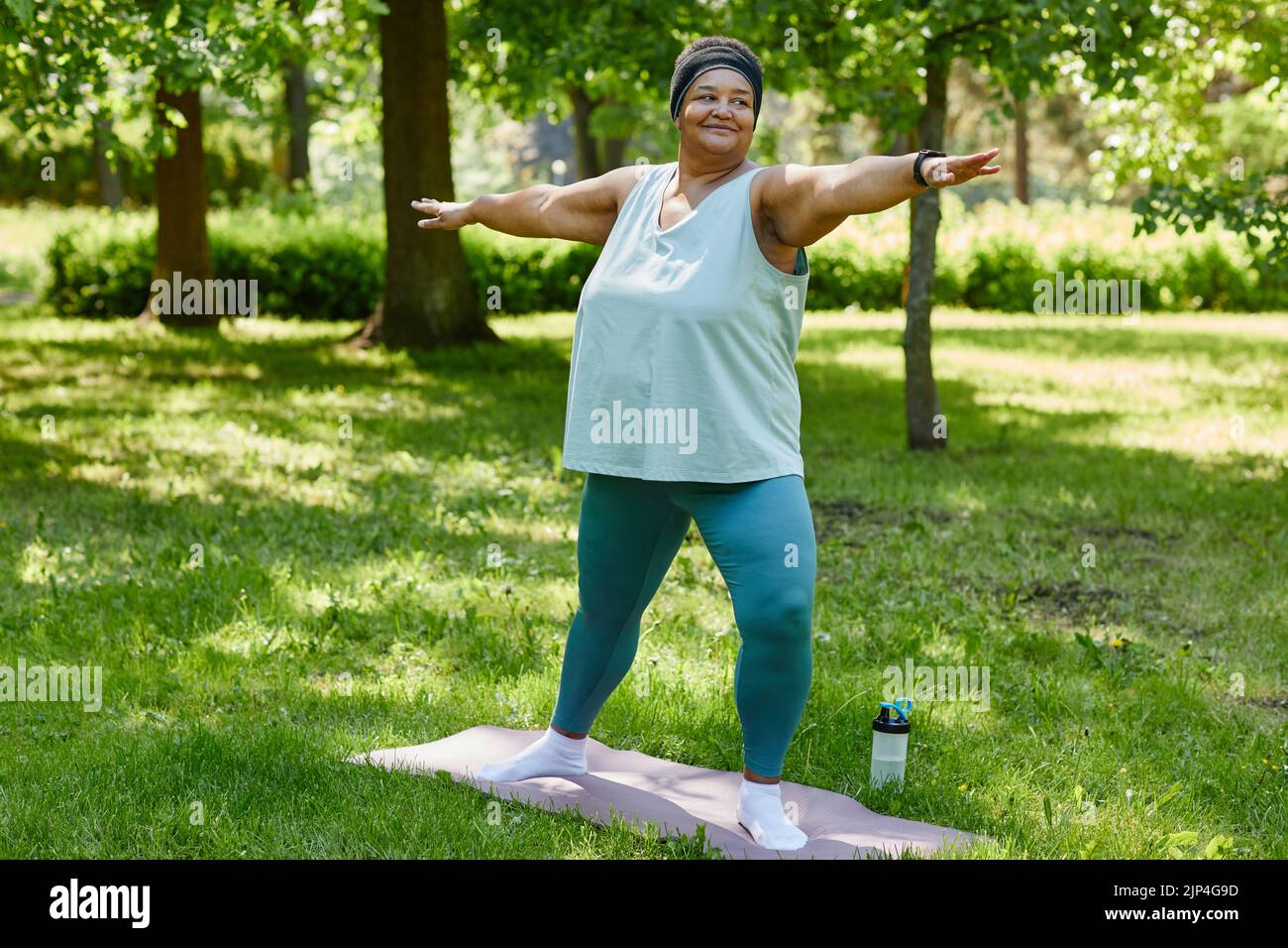 Full length portrait of overweight black woman working out outdoors in ...