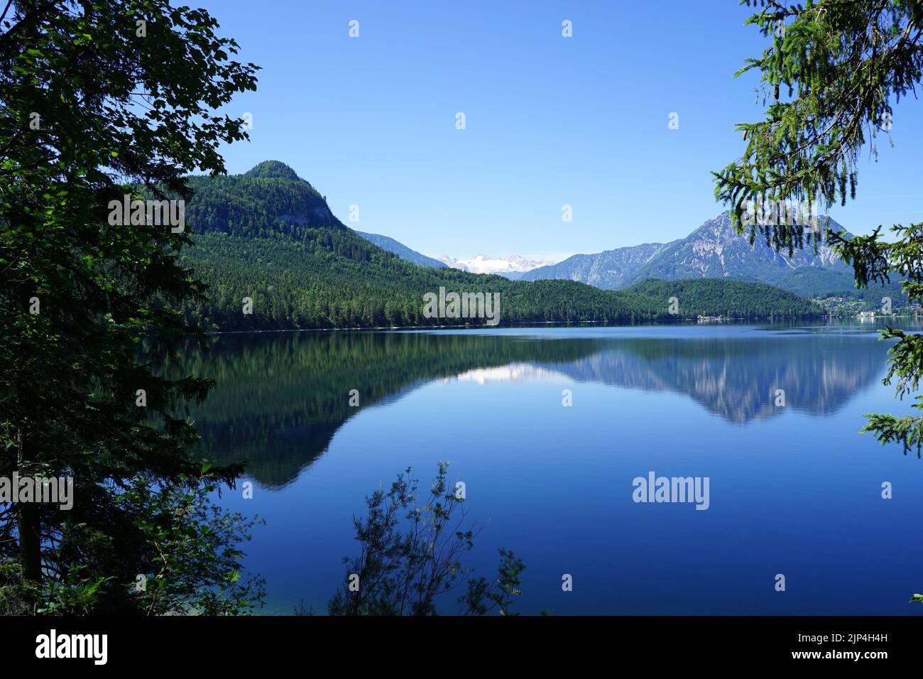 A beautiful view of a lake with the reflection of mountains and trees ...