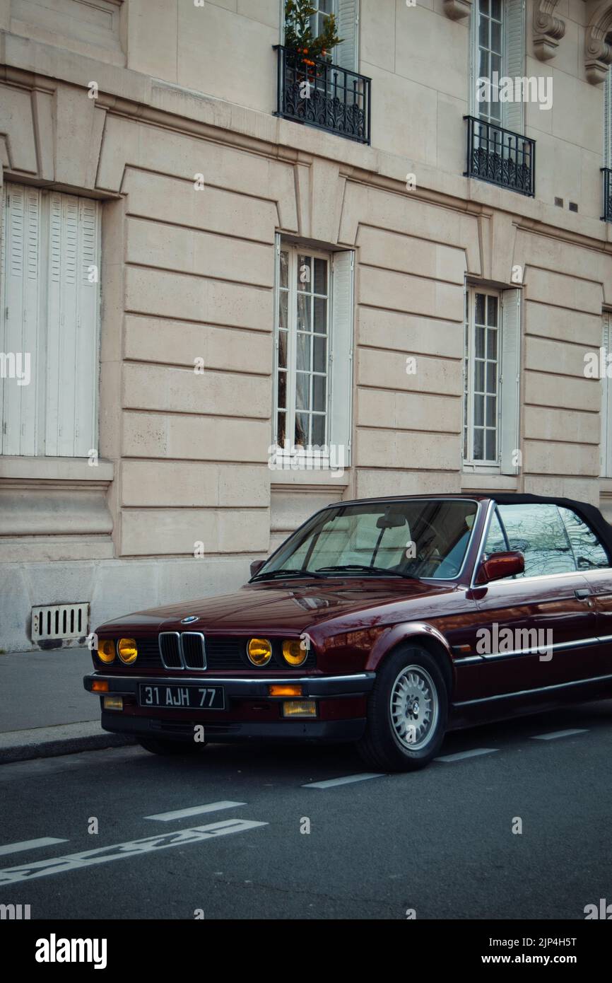 A vertical shot of a vintage BMW E30 in the streets of Paris, France ...