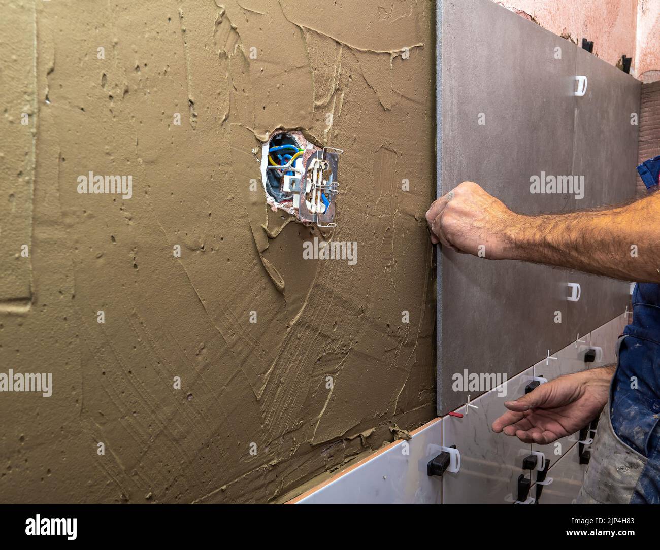 Laying wall ceramic tile. Renovating the wall. Construction worker ...