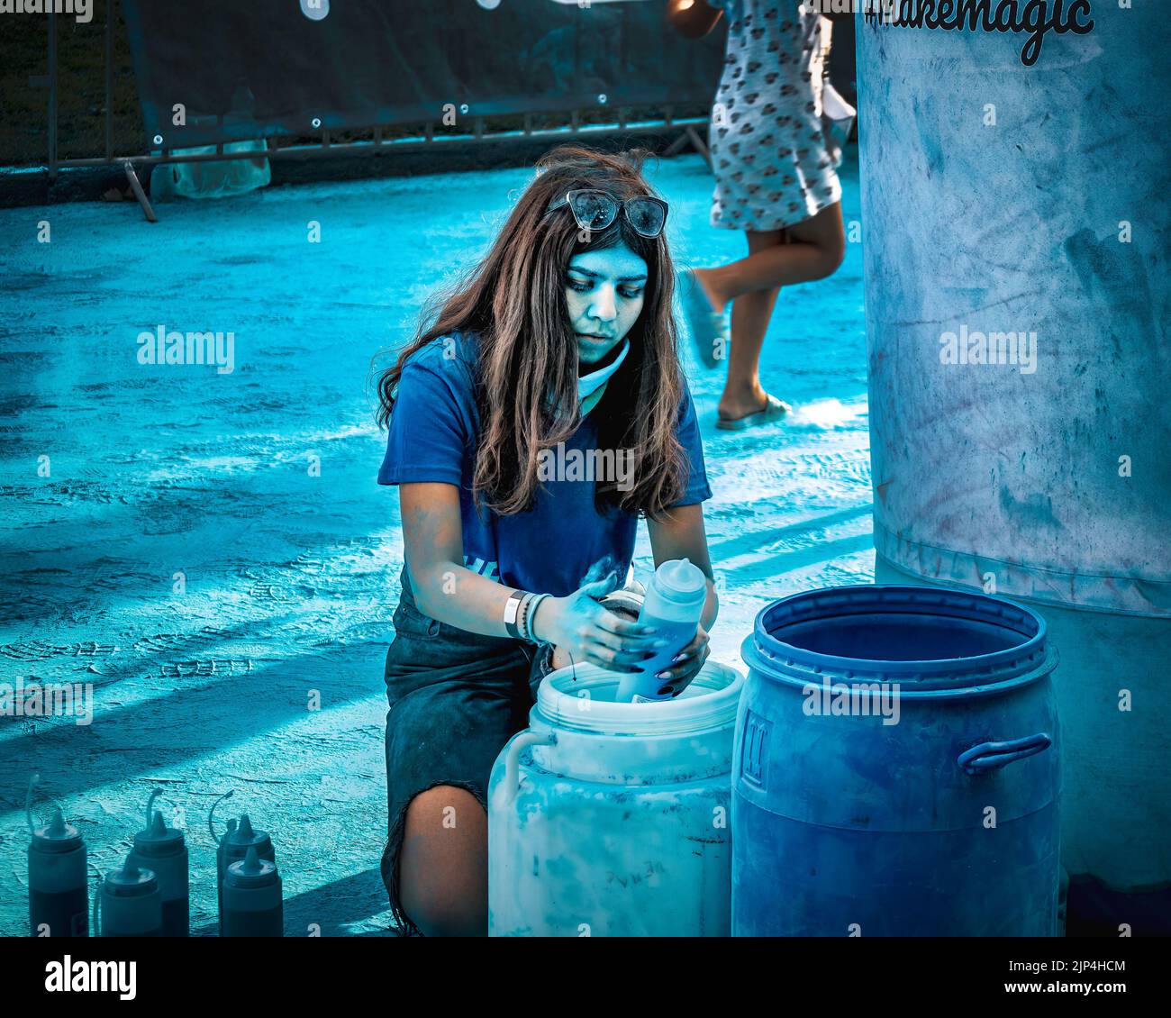 A woman mixing blue paint during the Color Run Festival in Bucharest ...
