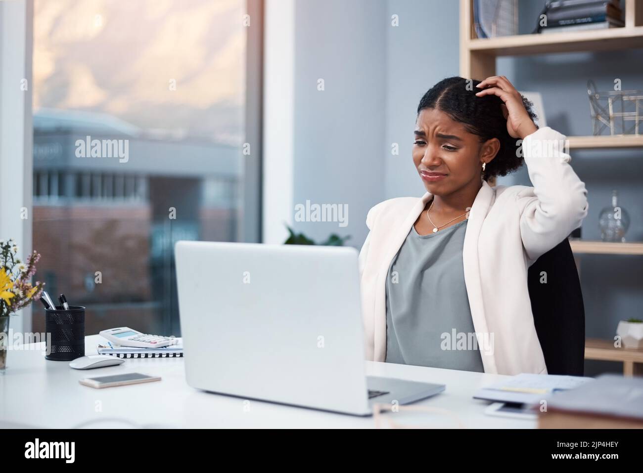I cant brain today. a young businesswoman looking confused while using ...