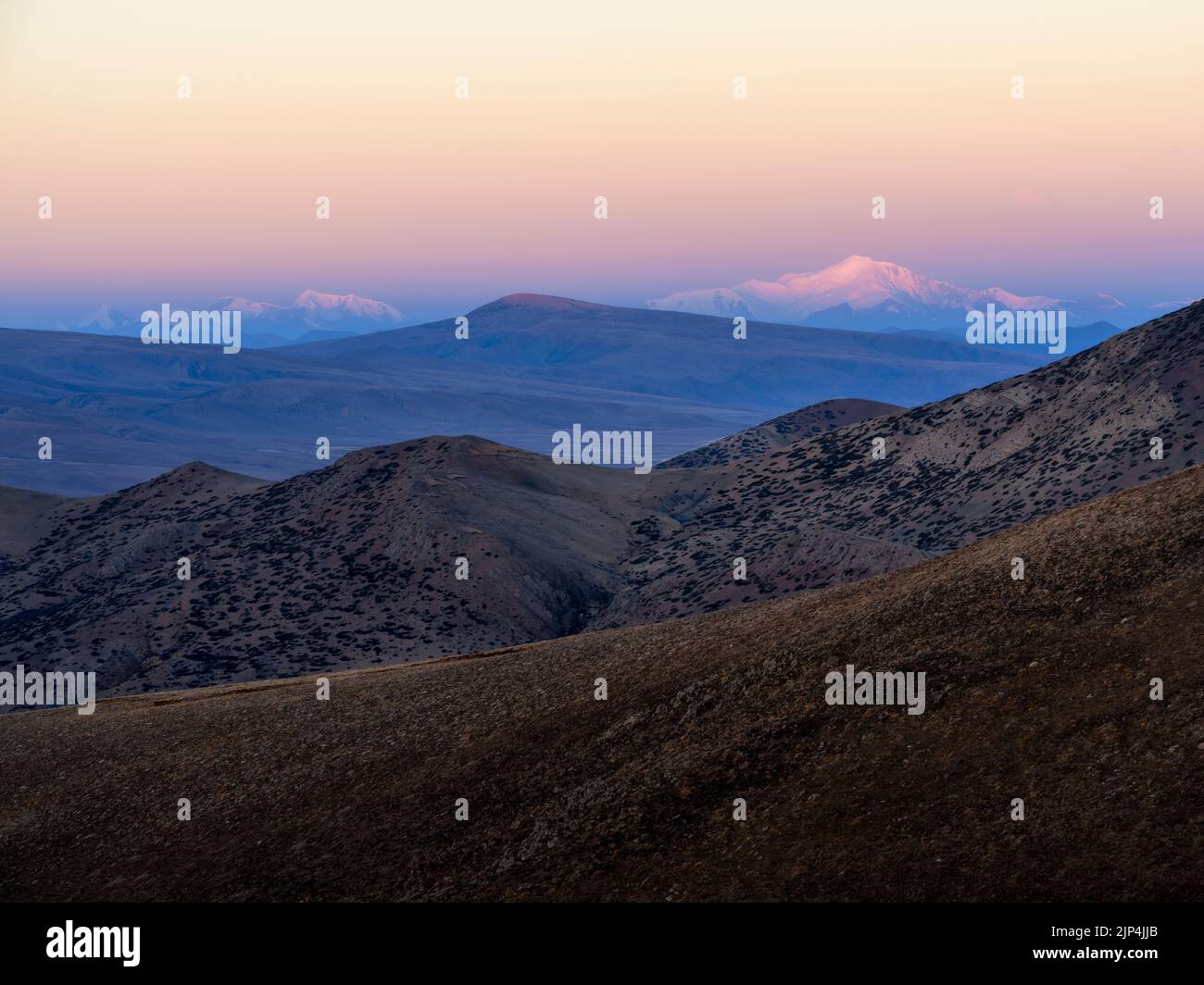 Scenic view of layered mountain ranges and Zhegu grassland, during ...