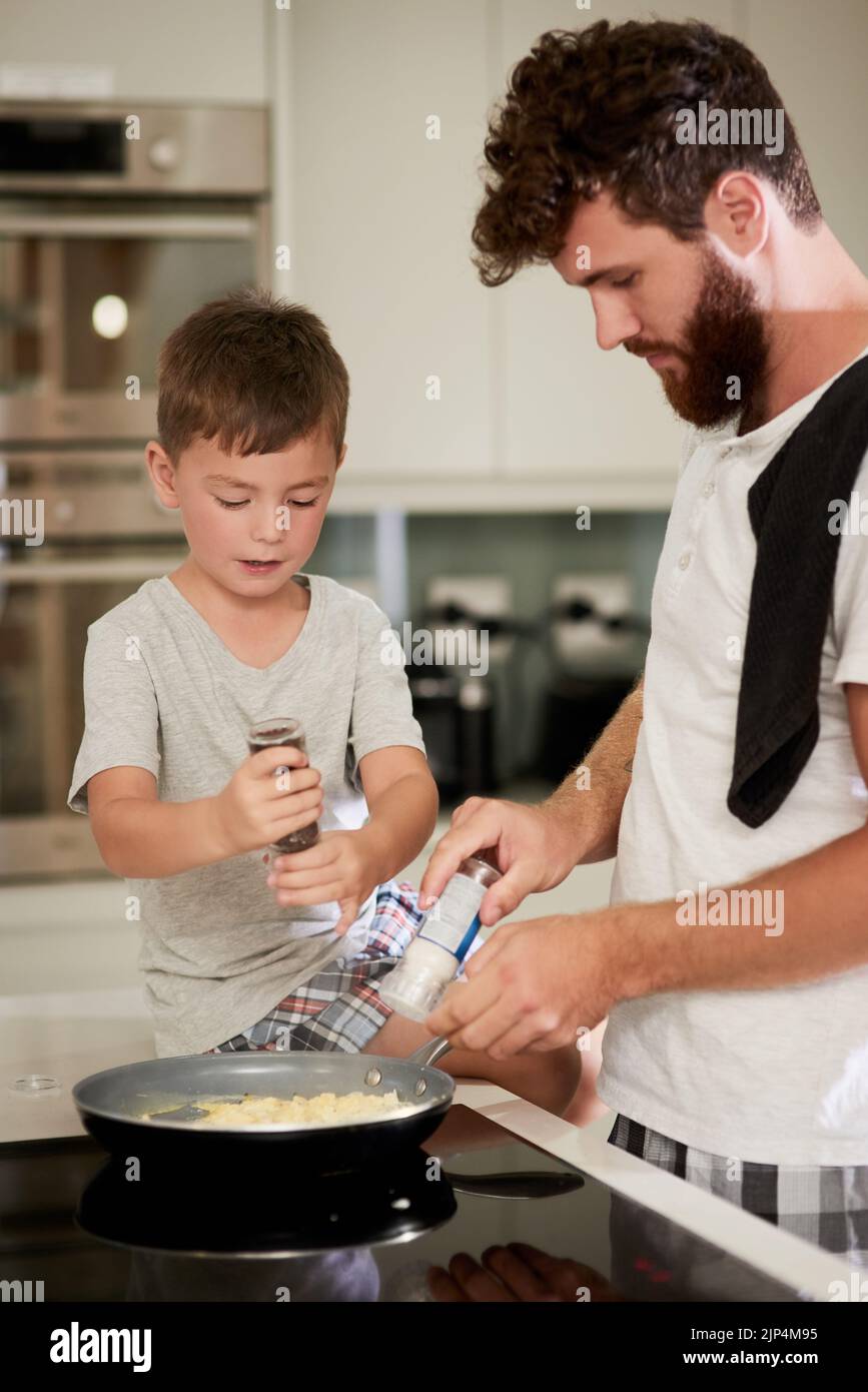 Teamwork makes breakfast work. an adorable little boy and his father ...