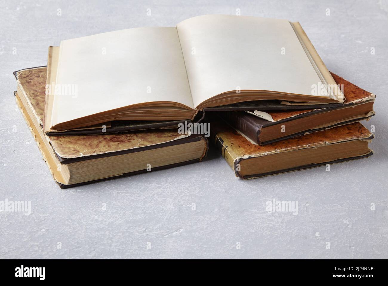 Open vintage book or notebook in a super jacket on a stack of old ...