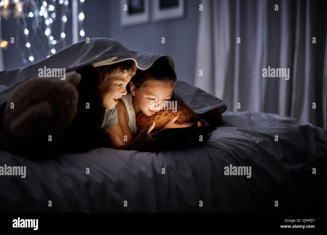 Theyre too entertained to sleep. two adorable little siblings using a ...