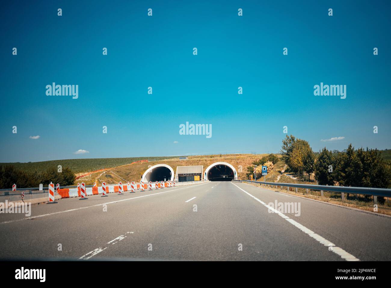 Two parallel highway roads with two tunnels under a blue sky Stock ...