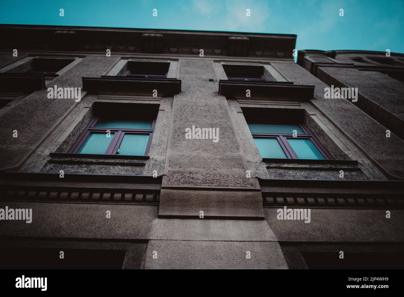 A low-angle closeup shot of a brown building with windows and a ...