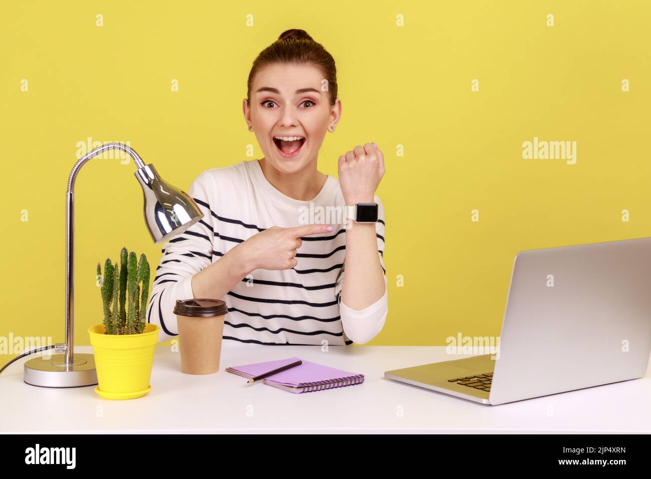 Look at clock, time to work. Positive hard working woman sitting ...