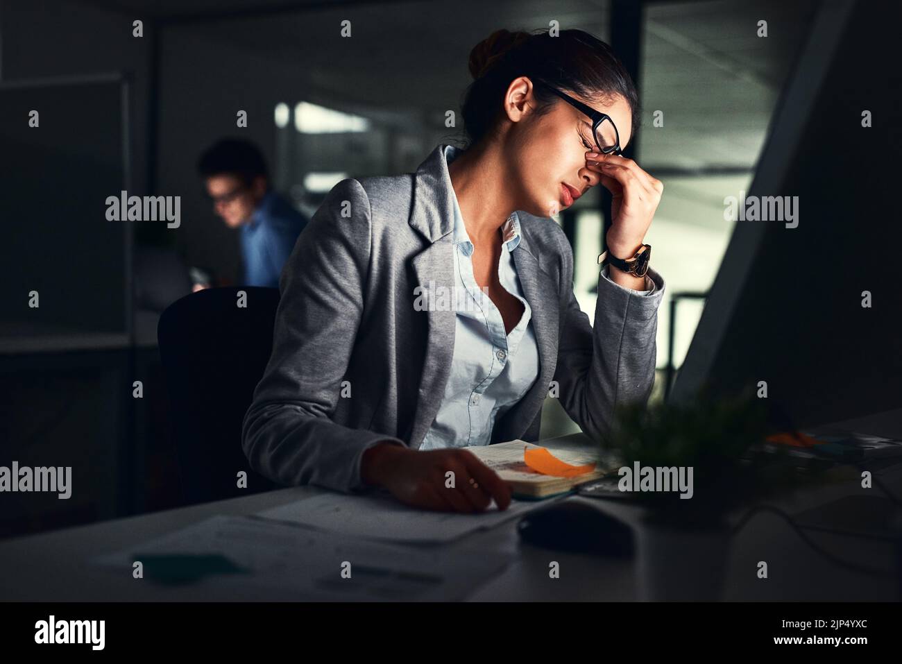 Stressed business woman working late on a computer in an office at ...