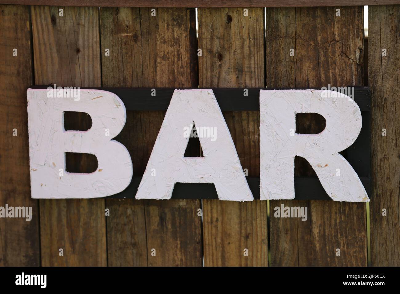 A closeup shot of a white "BAR" sign on a wooden door Stock Photo - Alamy