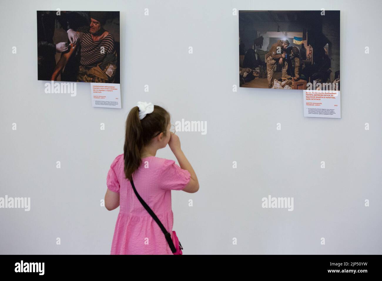 Kyiv, Ukraine. 14th Aug, 2022. A girl watches pictures by Azov soldier ...