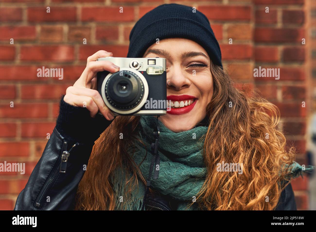 Smile for the camera. a young woman out in the city with her camera ...