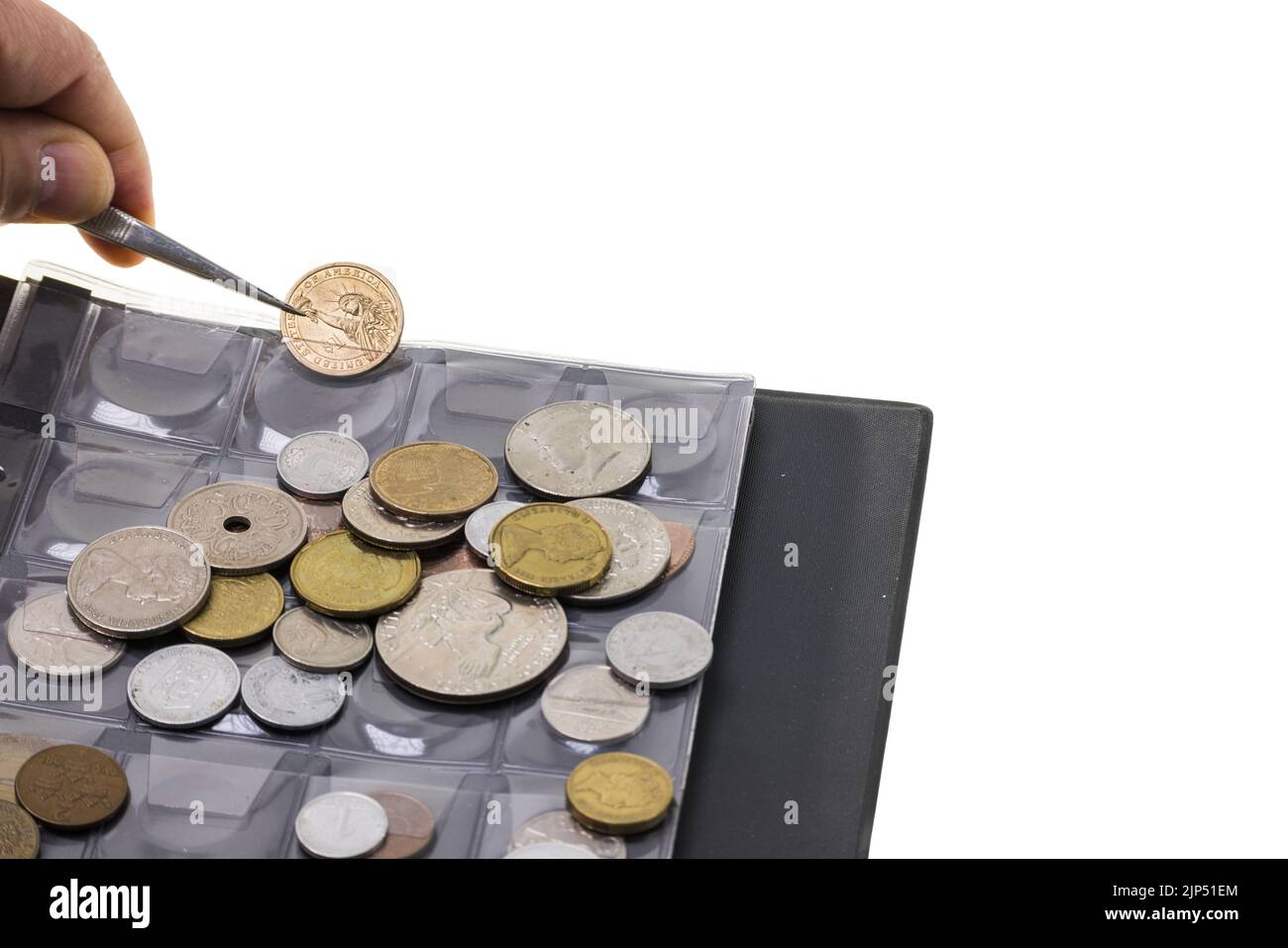 Close up view of tweezers in man's hand holding coin over coin ...
