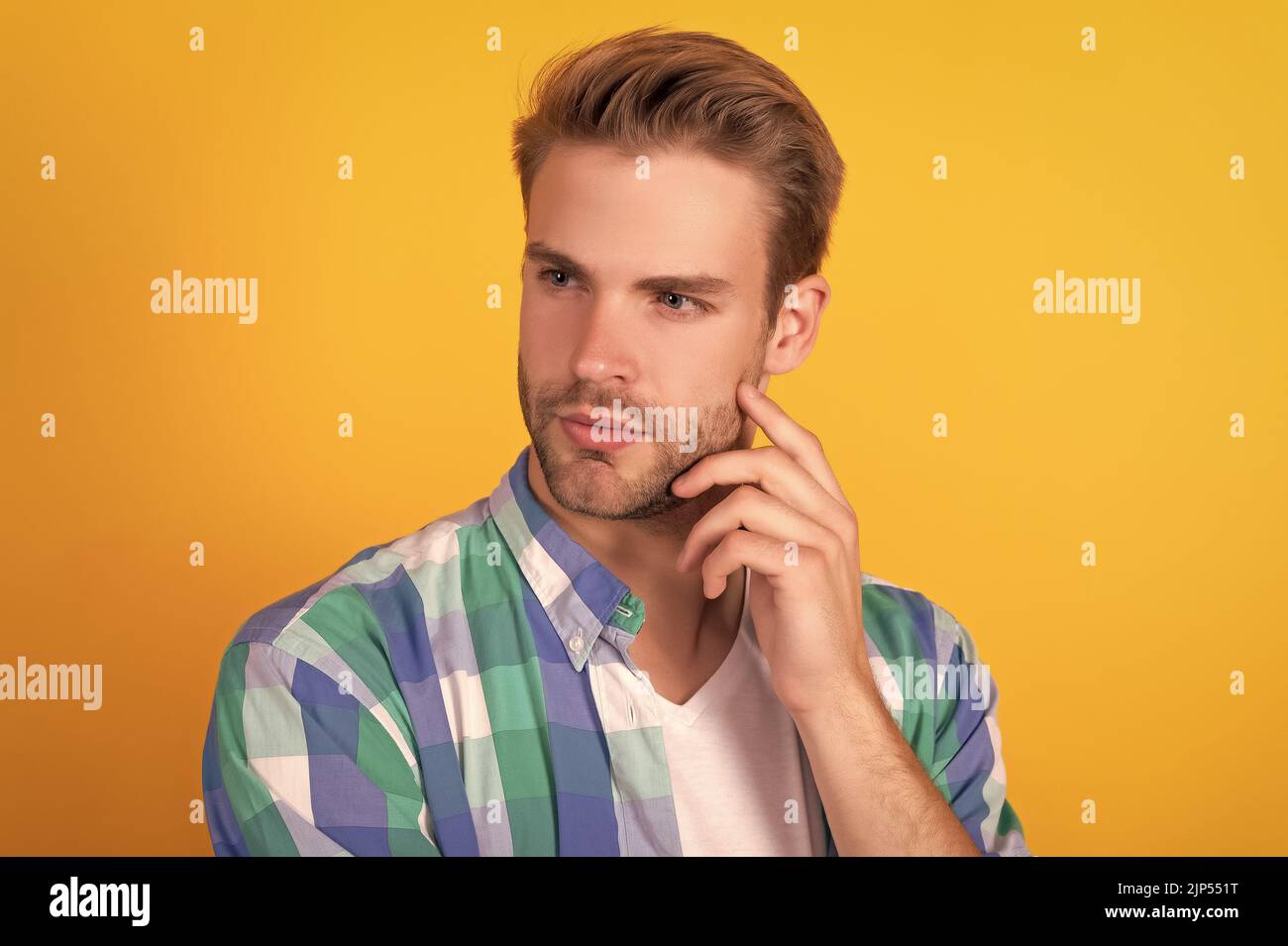 Portrait of serious young man with thoughtful face thinking yellow ...