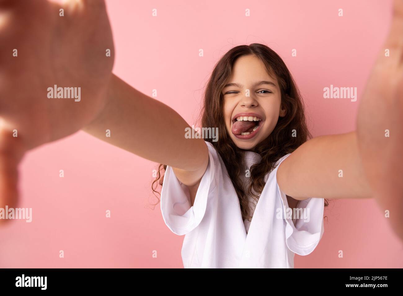Portrait of funny little girl wearing white T-shirt having positive ...
