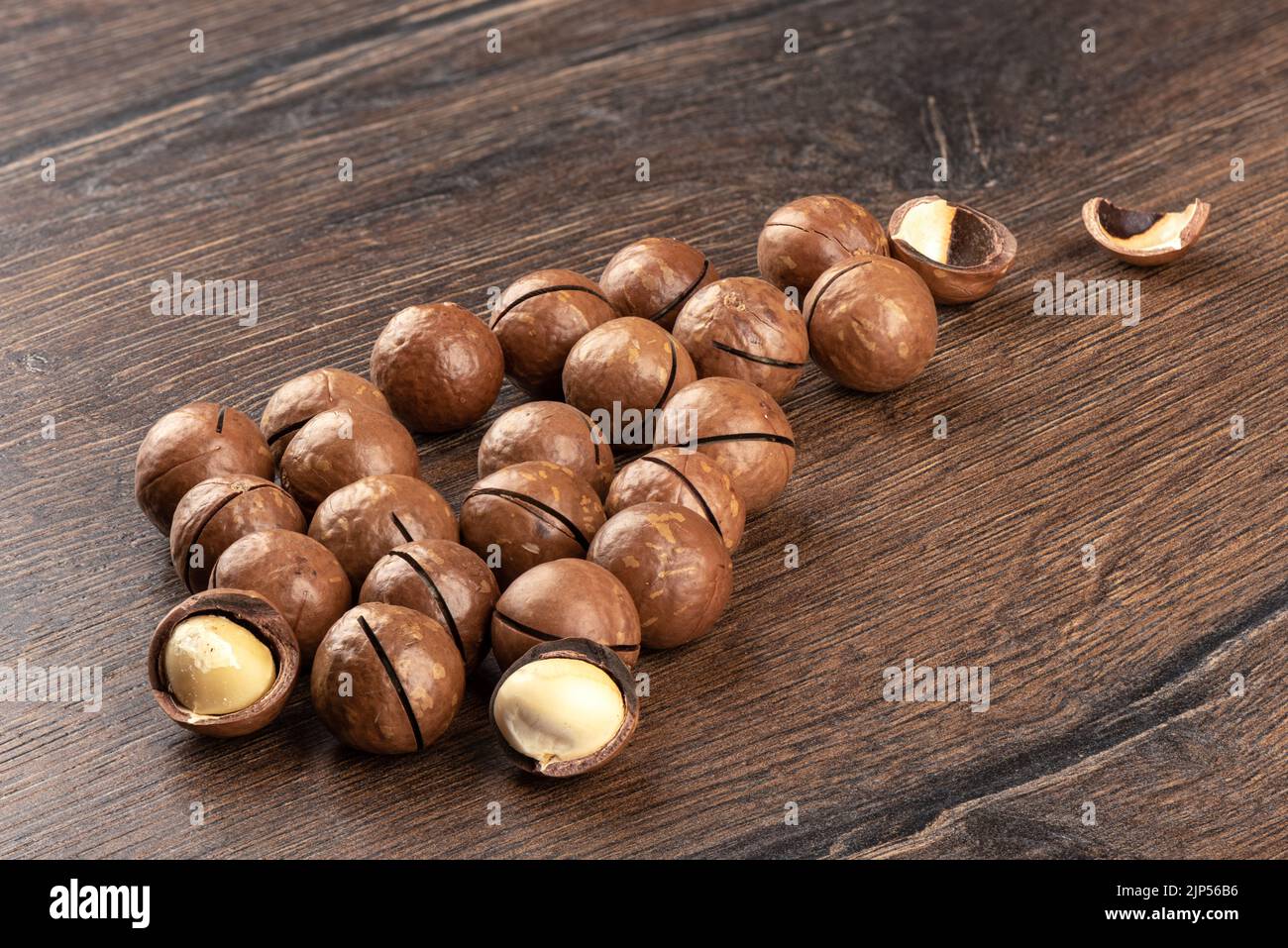 Macadamia nuts with notched shells and a few open nuts. Macadamia is a ...
