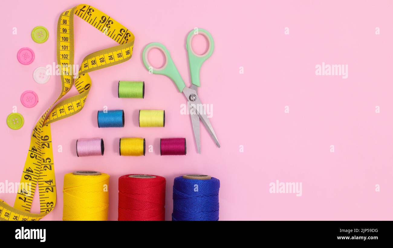 Sewing supplies and asccessories on pastel pink background with copy ...