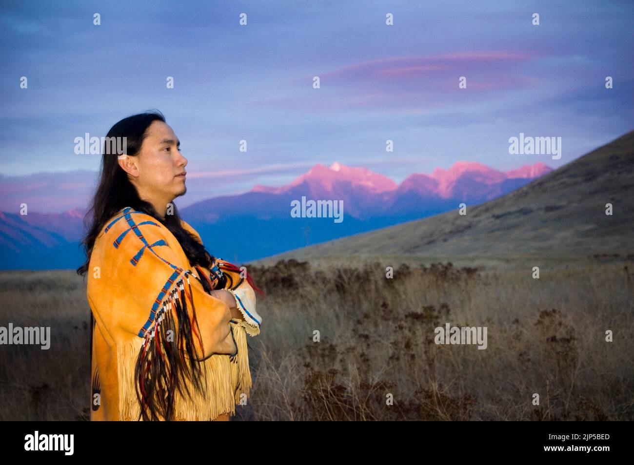 Native American teenage boy dressed in traditional beaded shirt with ...
