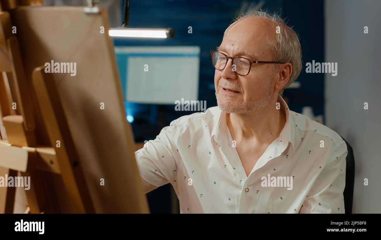 Retired man using artistic technique and pencils to draw masterpiece ...