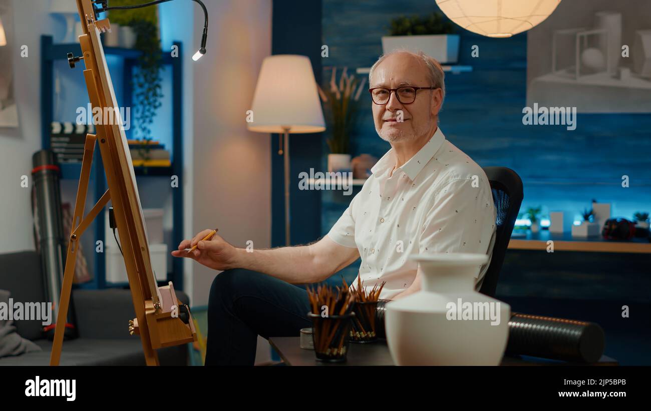 Portrait of male artist using tools to draw vase masterpiece with model ...