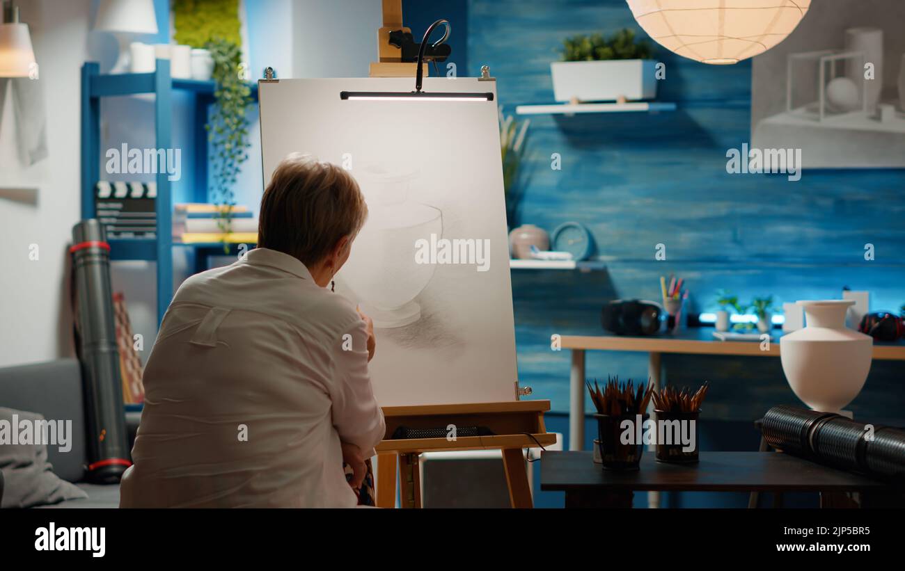 Senior adult drawing vase model inspiration with pencils and tools ...