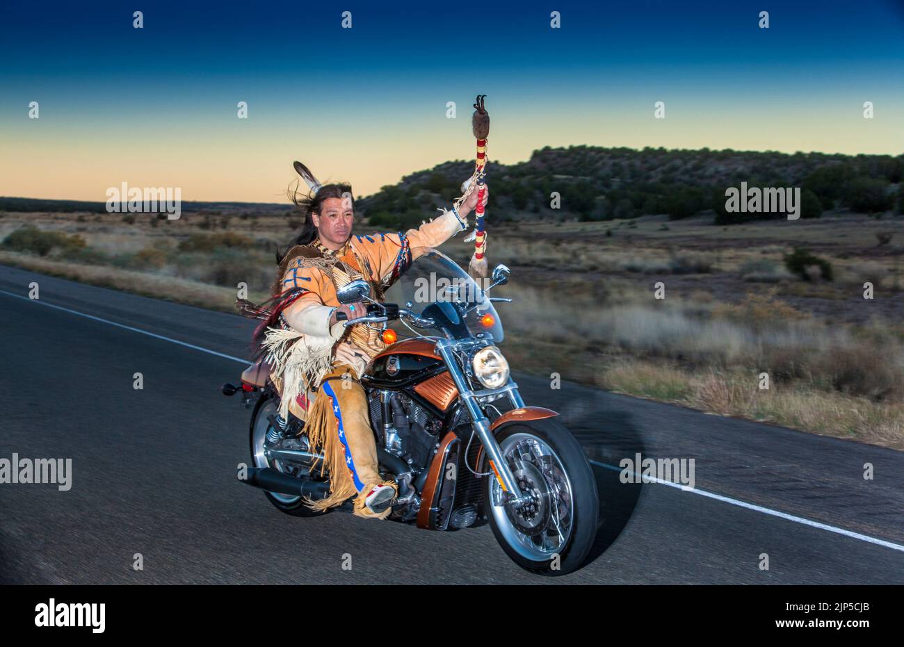 Traditionally dressed Native American man holds coupstick and rides ...