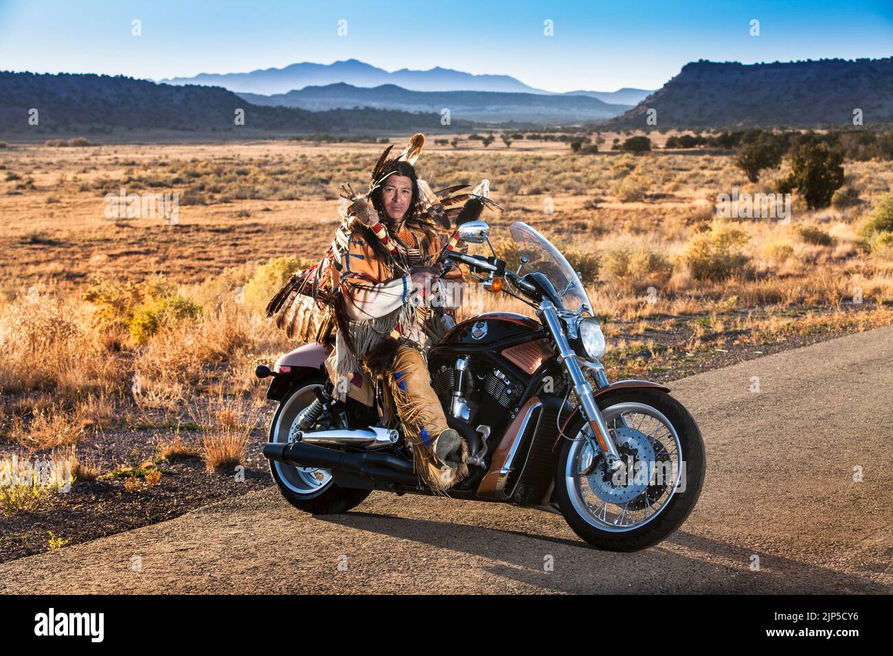 Traditionally dressed Native American man crosses two coupe sticks ...