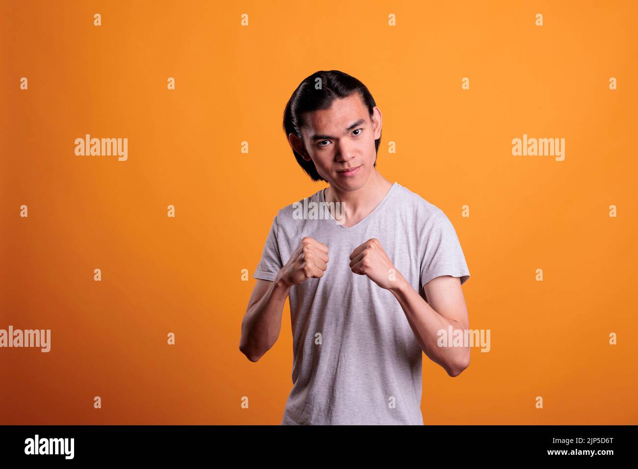 Serious strong young asian man standing in fighting pose, strength ...