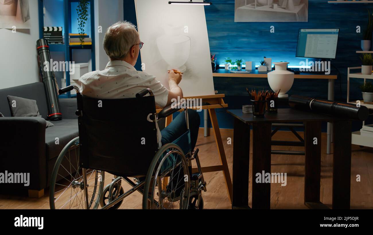 Senior man with disability drawing sketch of vase inspiration, using ...