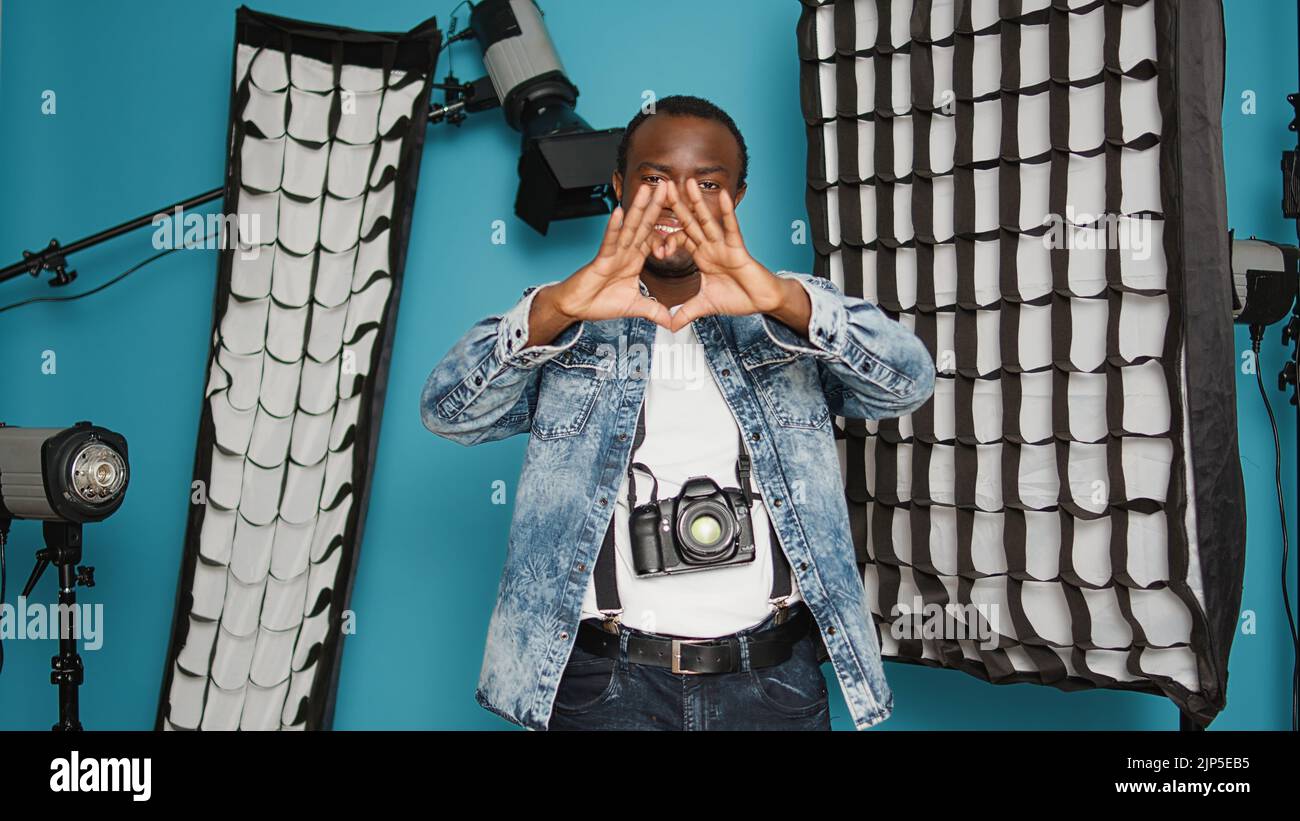 African american photographer doing heart shape symbol with hands ...
