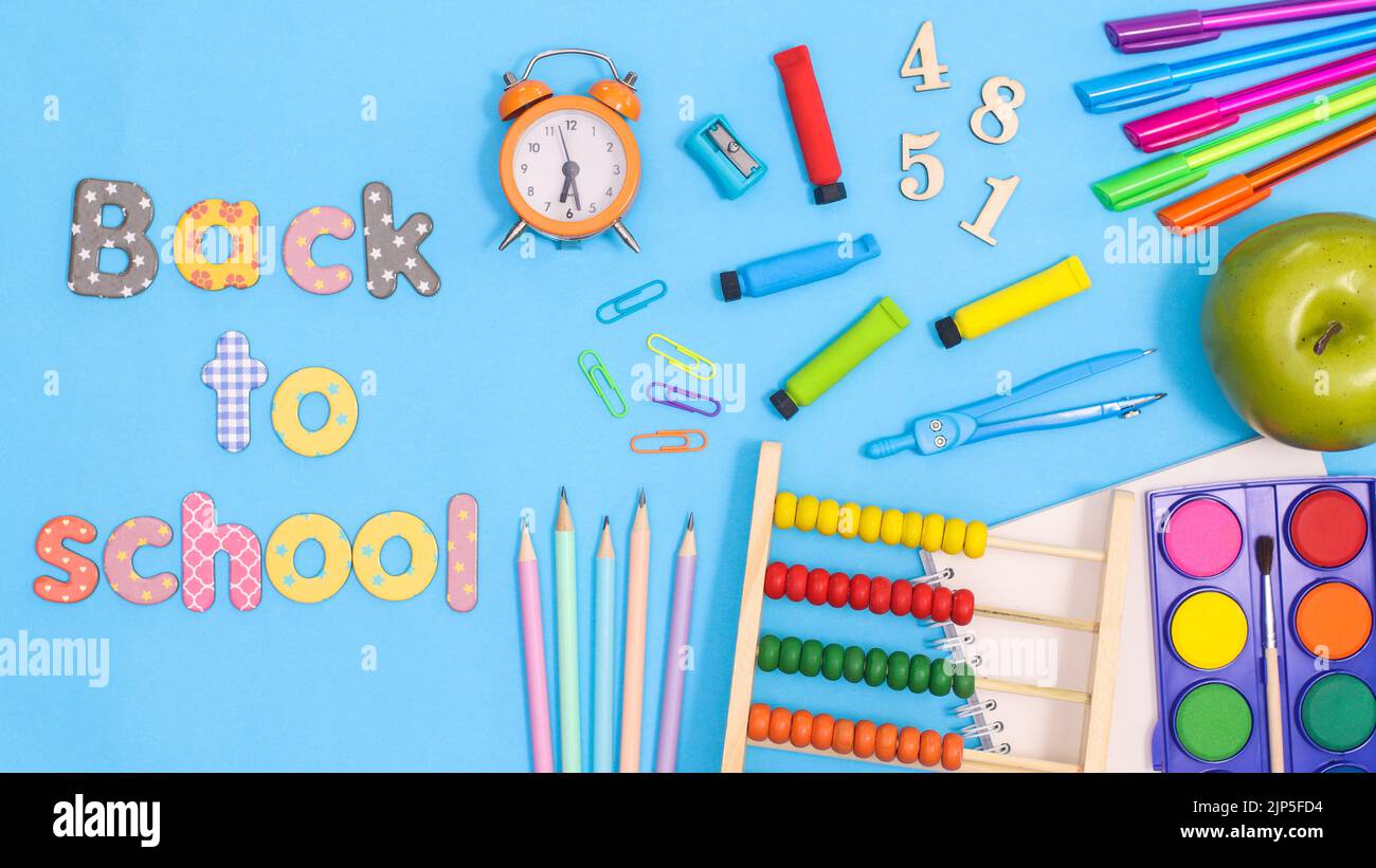 Back to school text with school supplies on pastel pink background ...