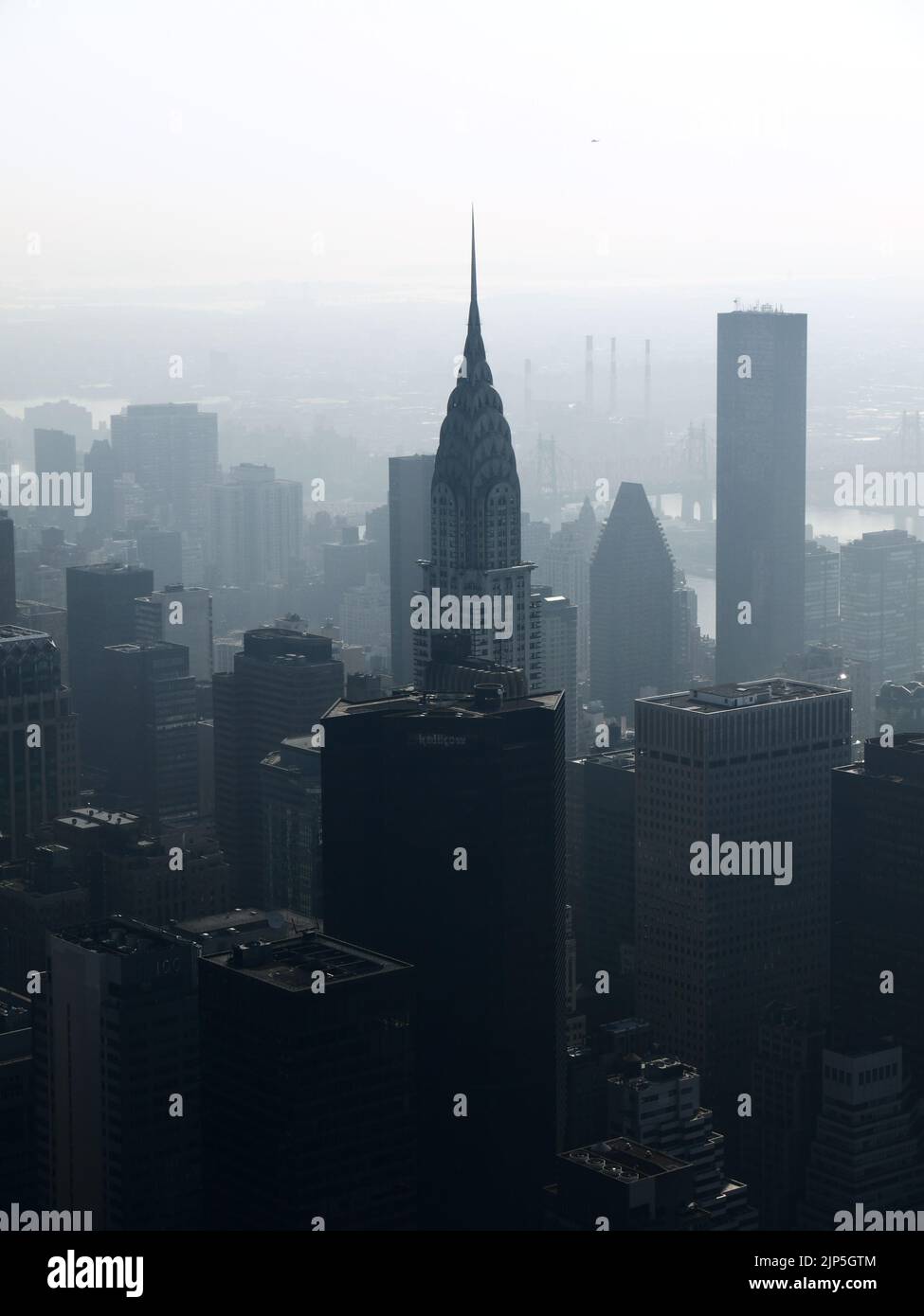 Chrysler Building in silhouette against a hazy Manhattan skyline, as ...