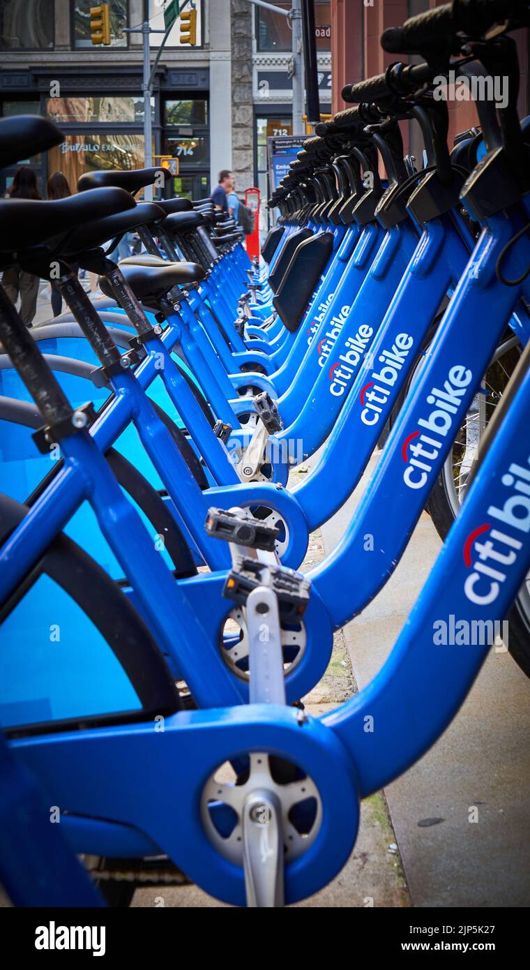 A vertical shot of a street bike station on a pavement in New York City ...