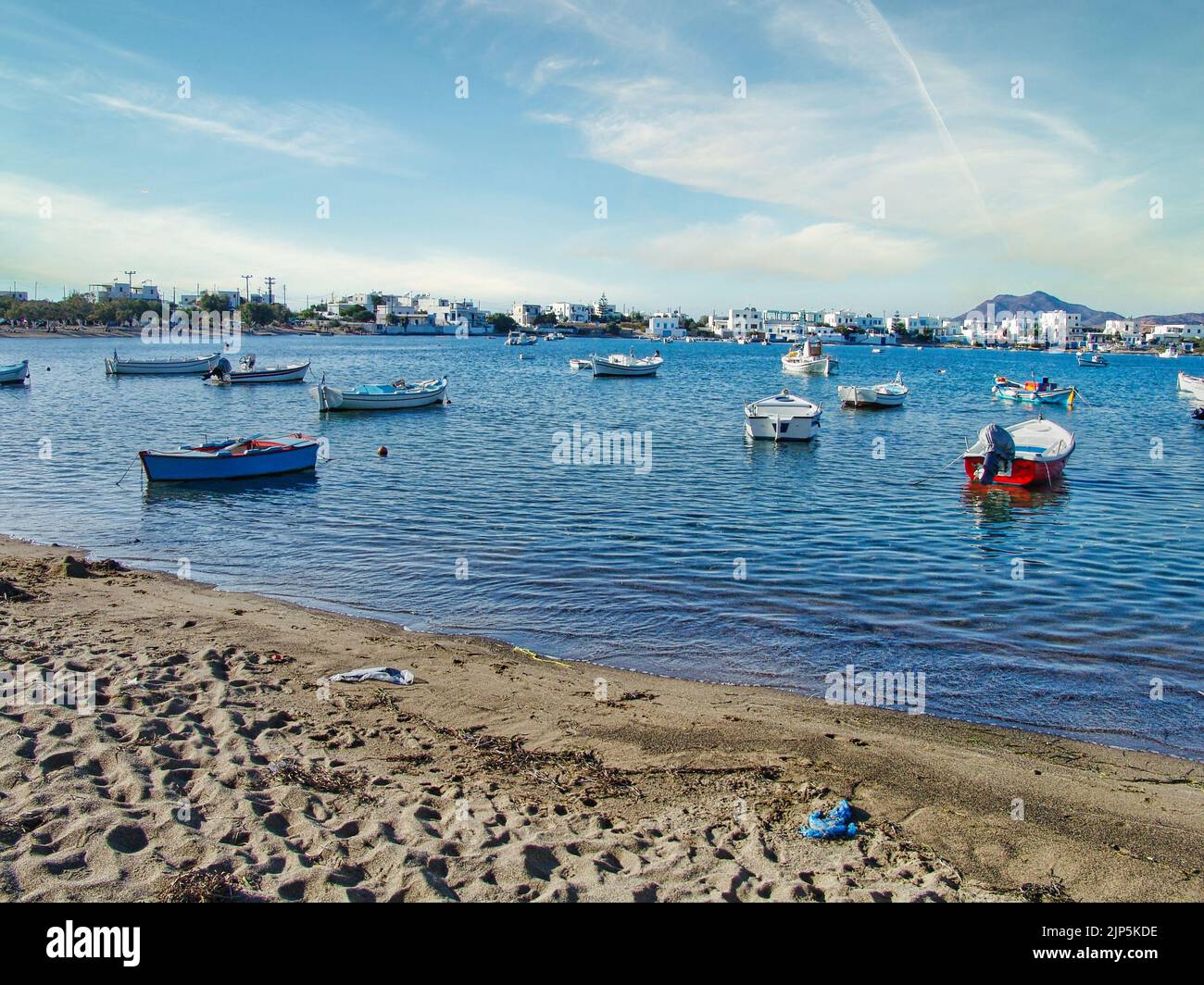 A small harbor with fishing boats and crystal clear turquoise waters in ...