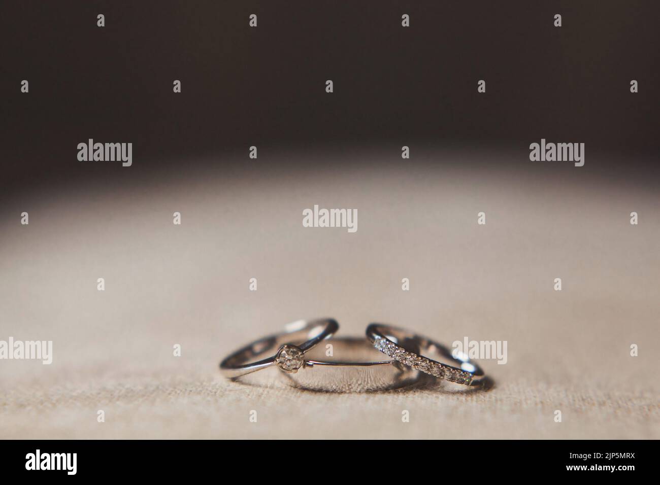 Three wedding rings on a beige background Stock Photo - Alamy
