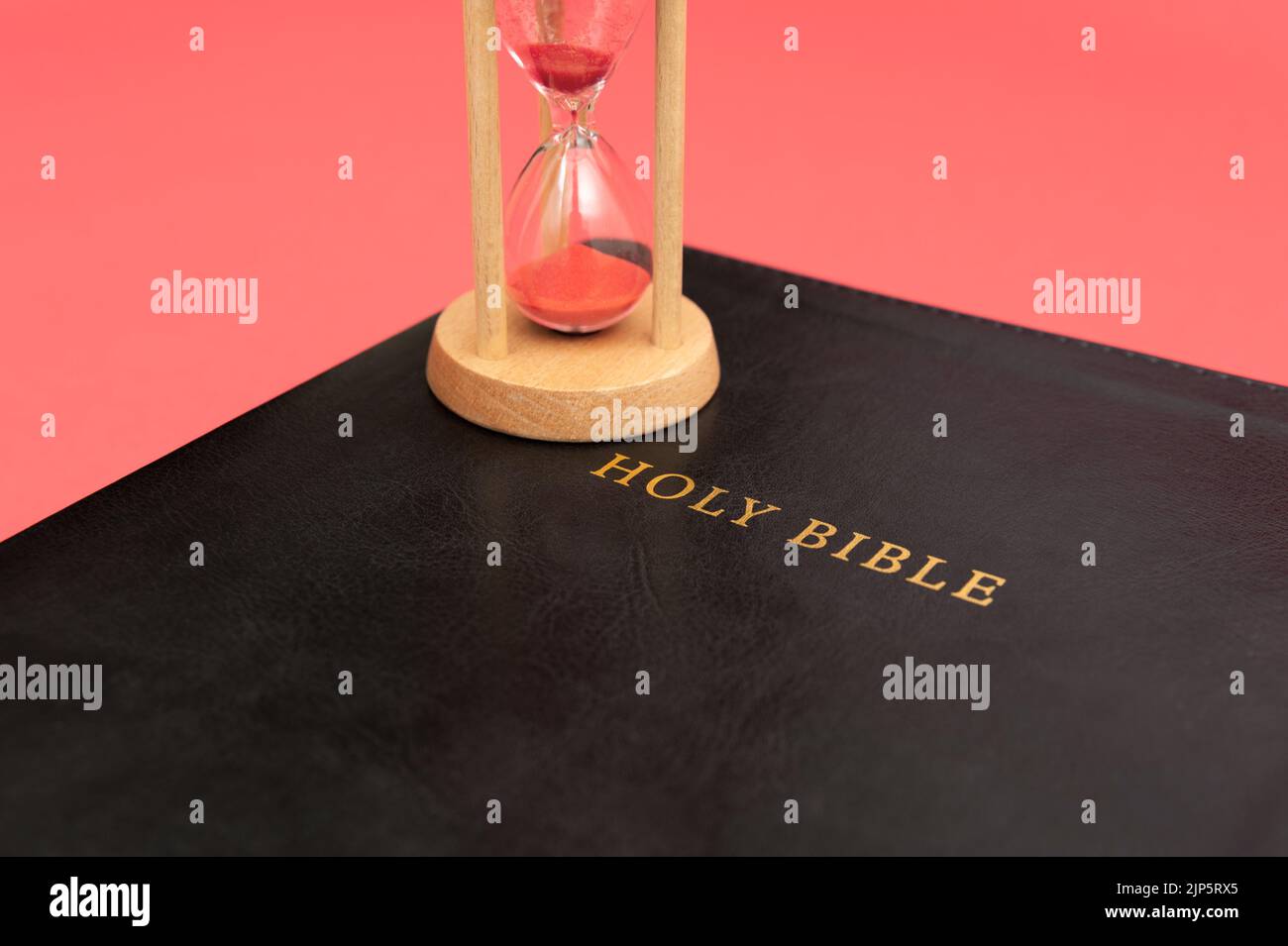 Holy Bible, the Word of God with hourglass. Isolated on red background ...